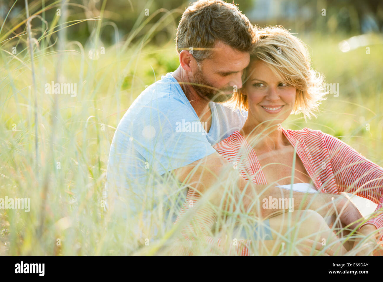 Caucasian couple hugging in tall grass Stock Photo - Alamy
