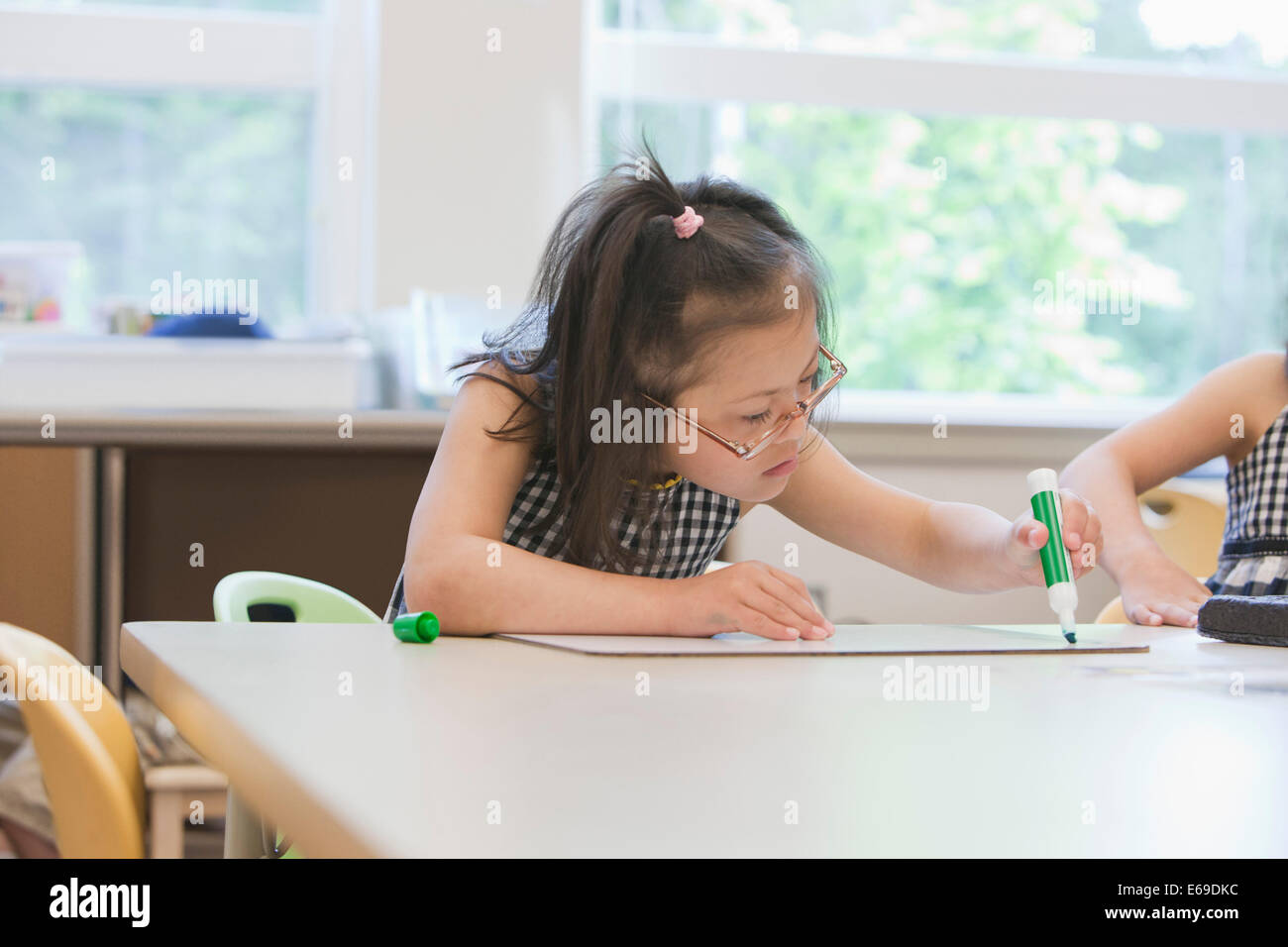 Mixed race Down syndrome students drawing in class Stock Photo - Alamy