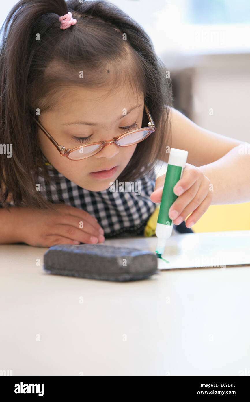 Mixed race Down syndrome student drawing in class Stock Photo - Alamy