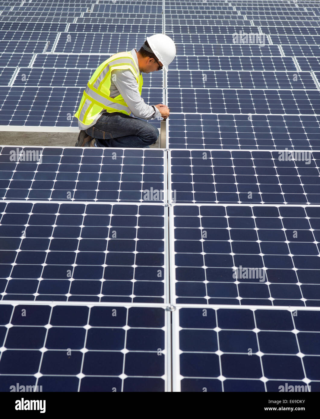 Asian technician working on solar panels Stock Photo - Alamy