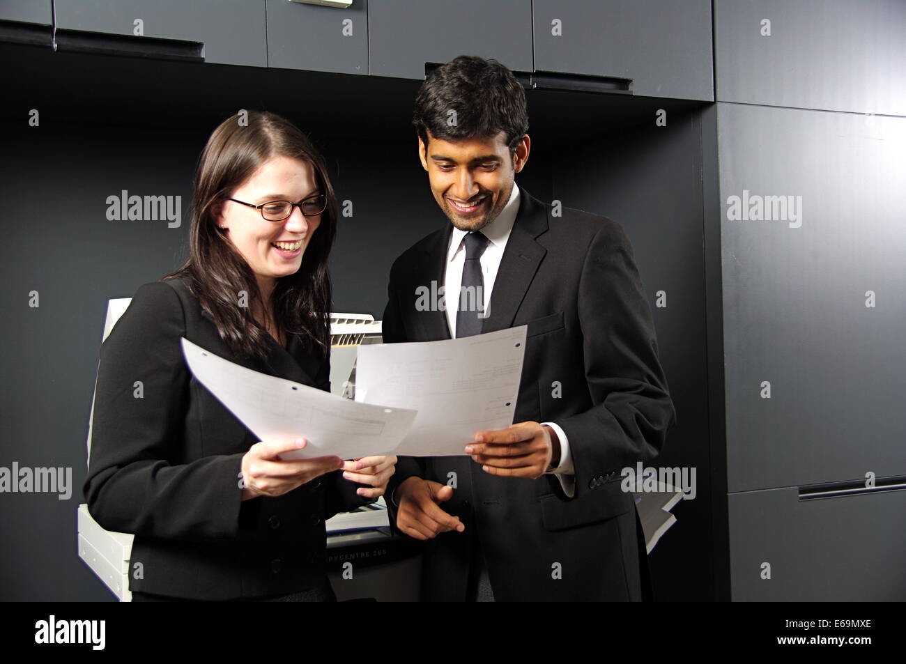 Two business people comparing papers Stock Photo - Alamy