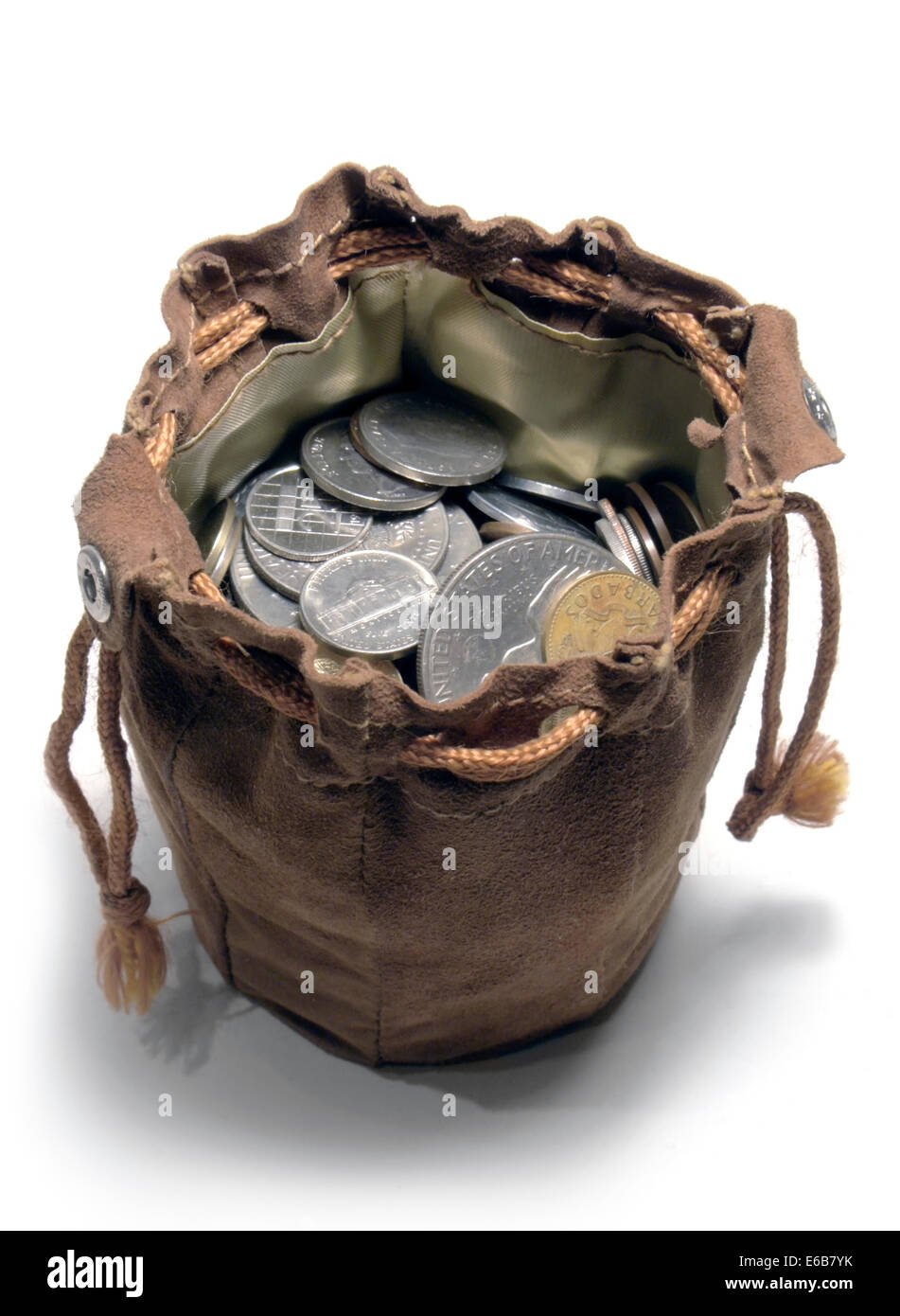 studio photography of a open leather moneybag filled with coins seen ...