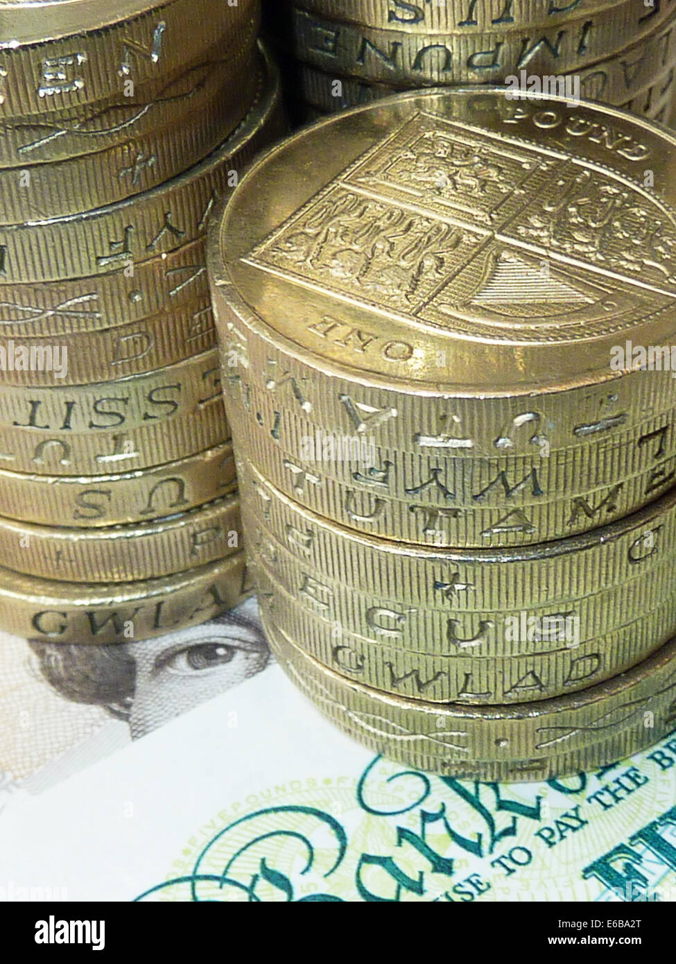 Stack of pound coins resting on UK banknotes Stock Photo - Alamy