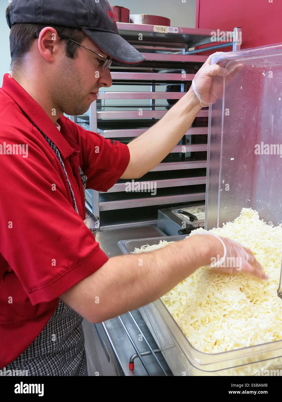Small Business Owner of Pizza Shop (pizzeria) Filling Grated Cheese bin ...