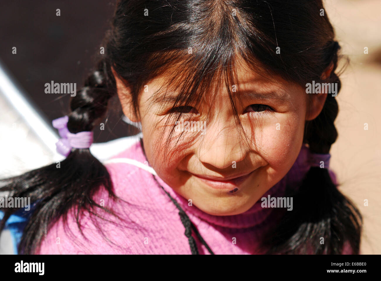 Bolivia, El alto, portrait of a cute smiling girl with plaited hair ...