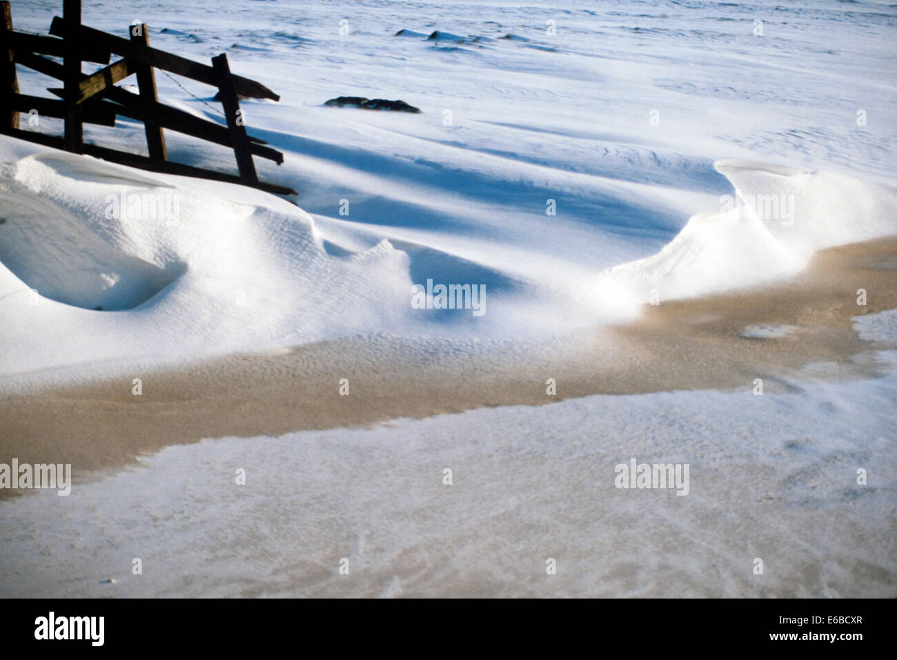 windblown snow forms drifts at the side of a frozen canal Stock Photo ...