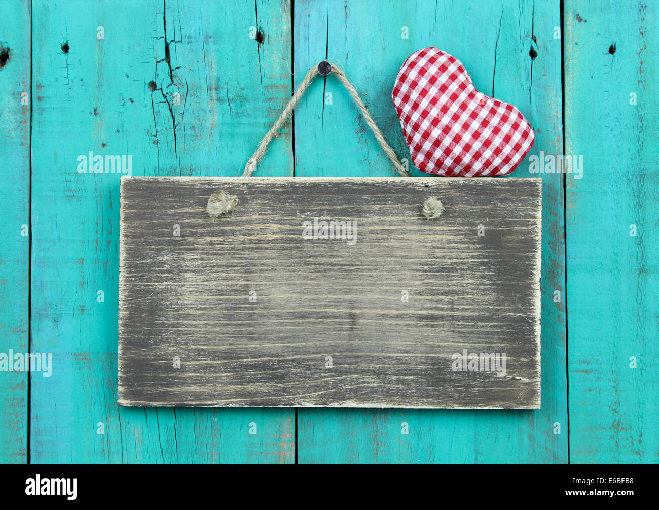 Blank distressed sign with red checkered heart hanging on rustic ...