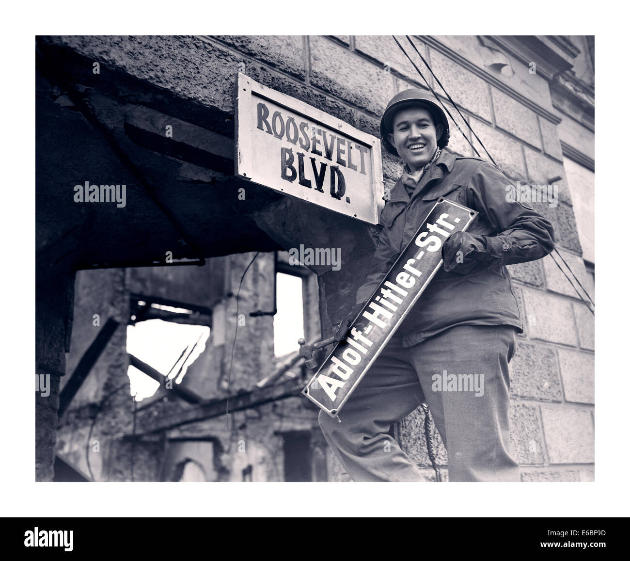 1940's American GI replacing a street sign in Berlin after the defeat ...