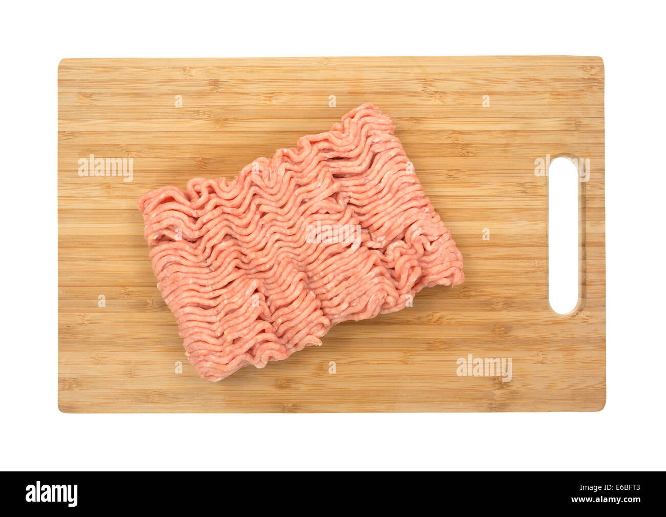 Top view of a portion of fresh ground chicken on a wood cutting board ...