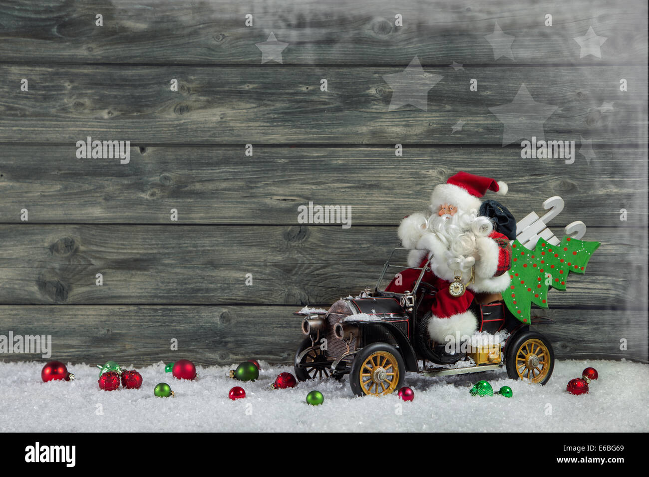 Santa Claus with vintage car, presents and tree on wooden snowy ...