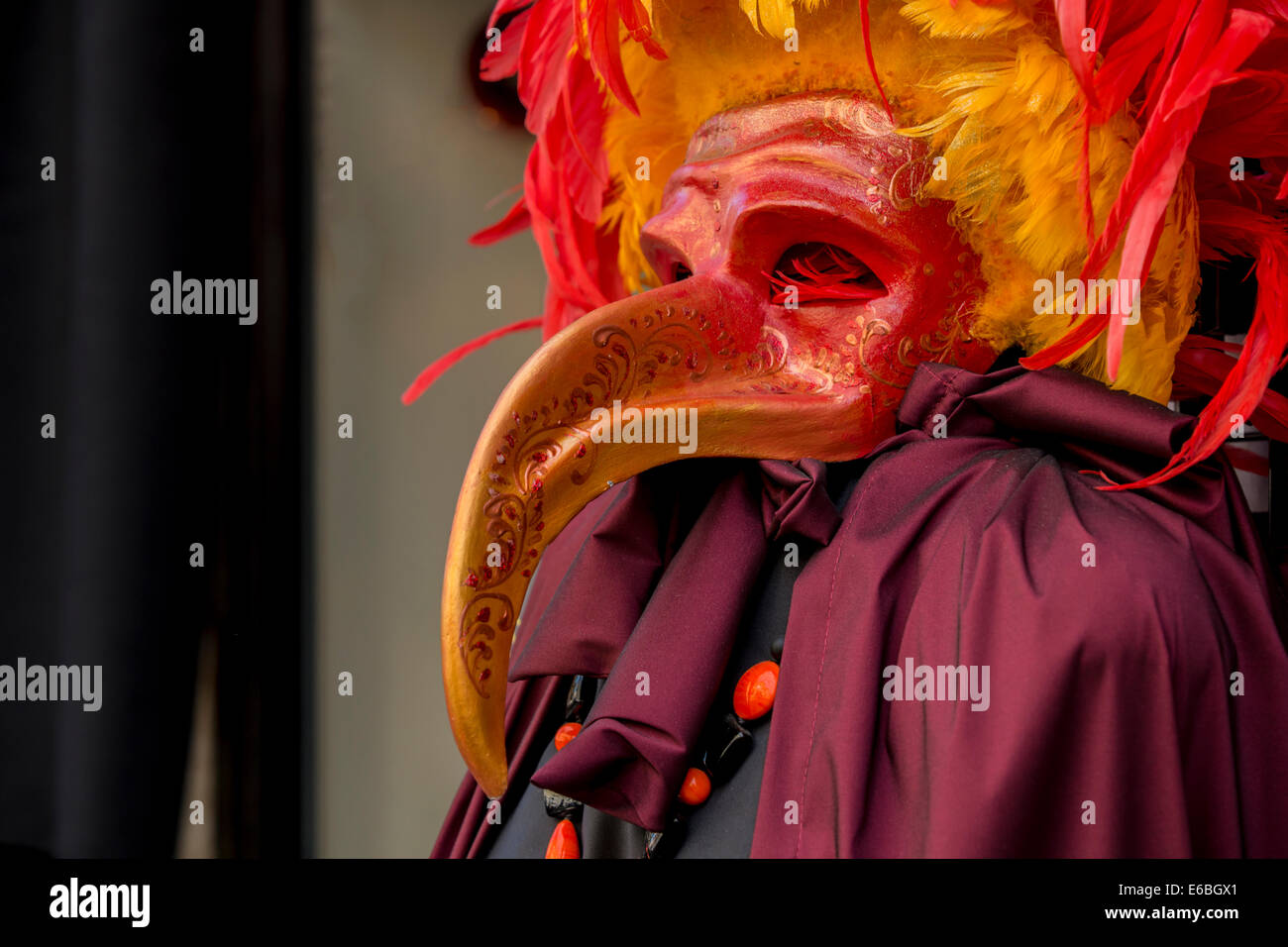 A red and yellow plague doctor costume in the window of a shop in ...