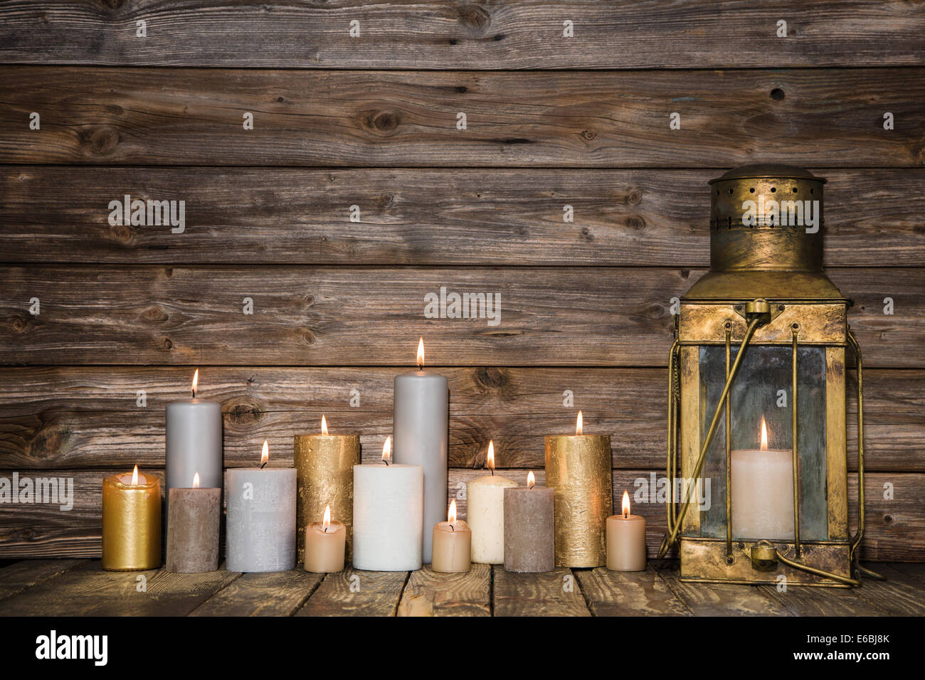 Wooden vintage background in with many burning candles and a old rustic ...