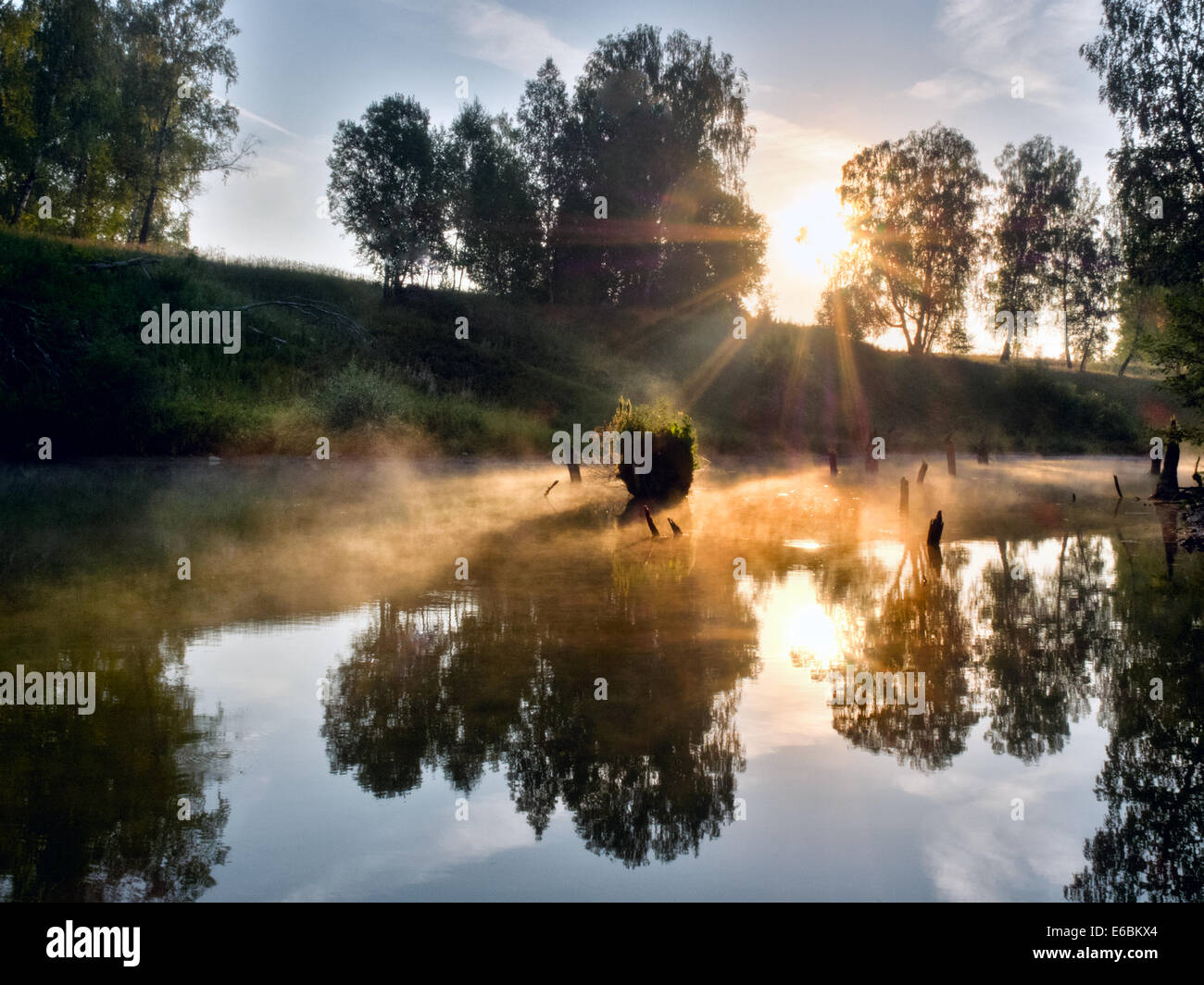 Foggy sunrise with visible sun-rays Stock Photo - Alamy