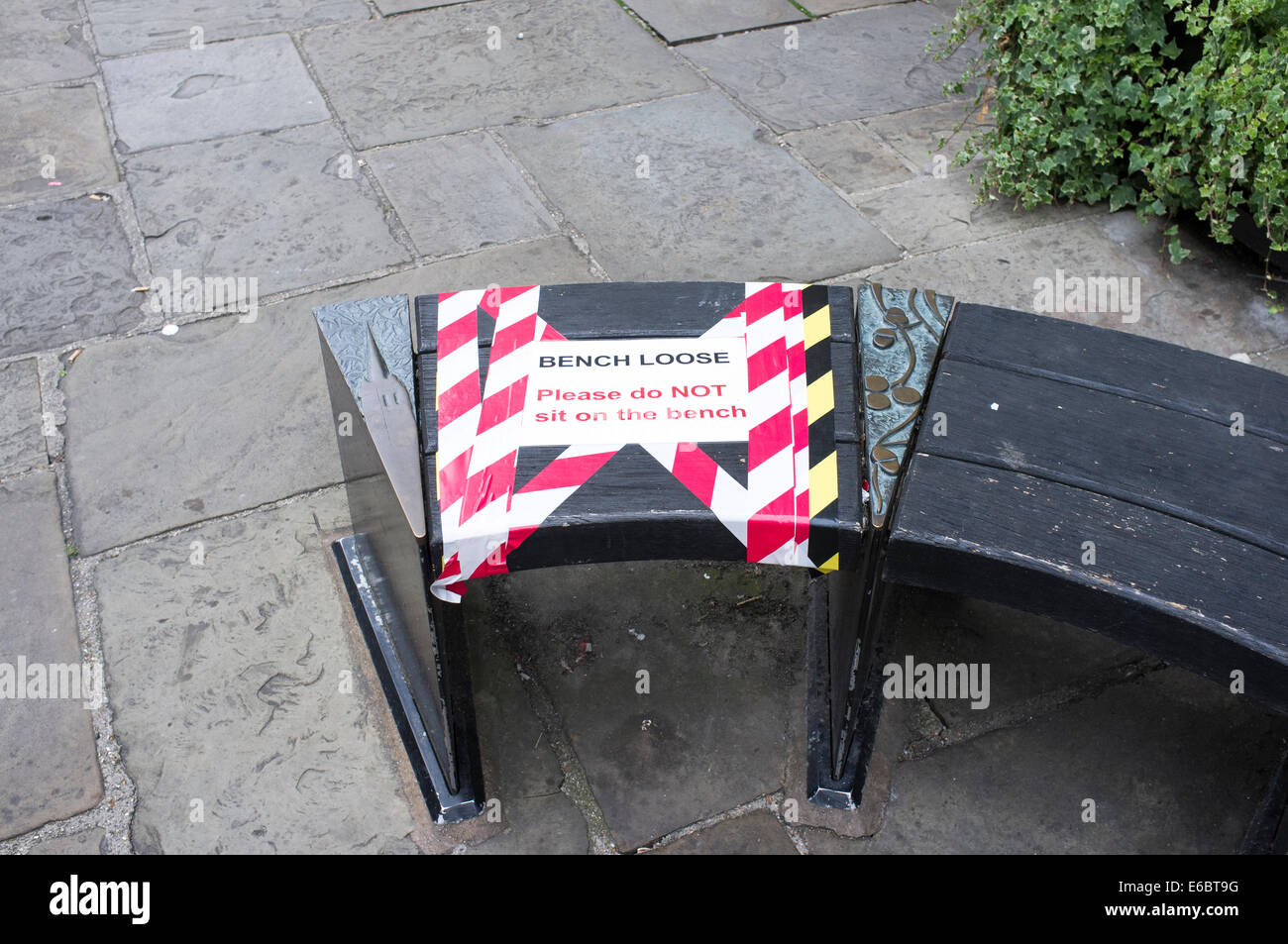 Unsafe public bench seat notice with red and white danger warning tape ...