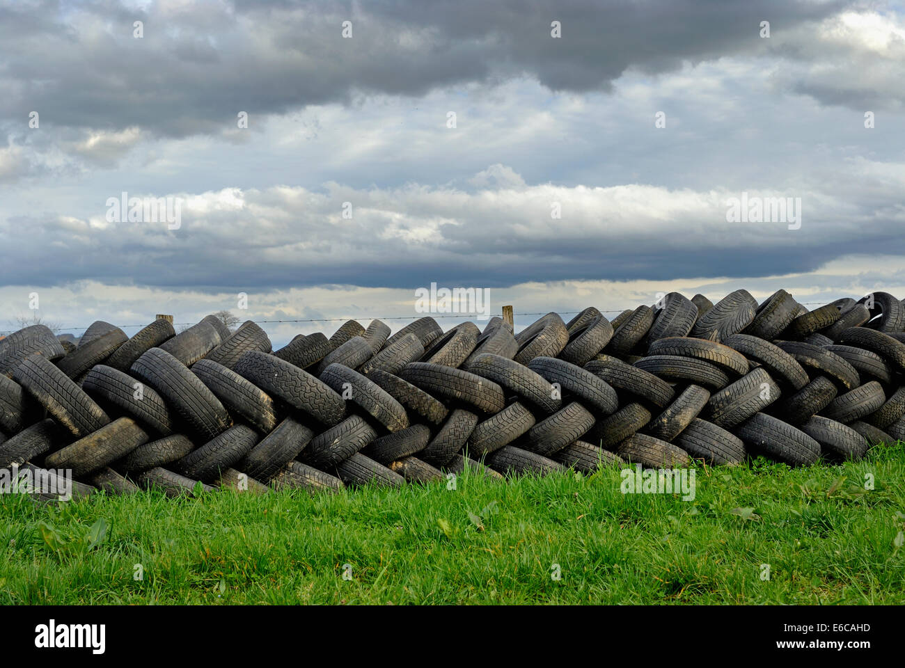 Stack of old used tires in a green field Stock Photo - Alamy