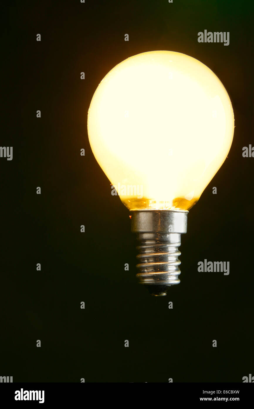Shining light bulb close-up over black background Stock Photo - Alamy