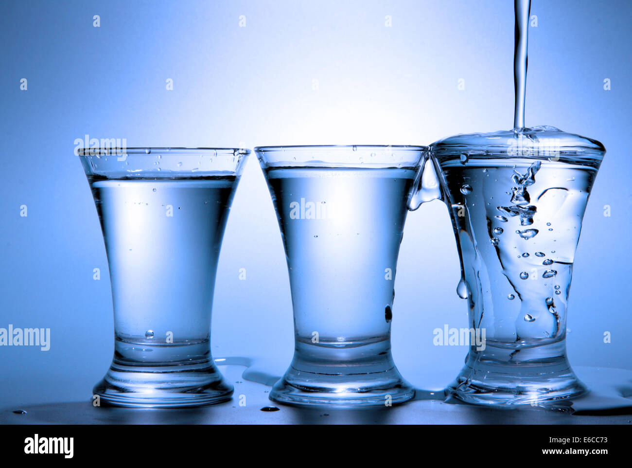 Vodka pour into glass toned in blue color Stock Photo - Alamy