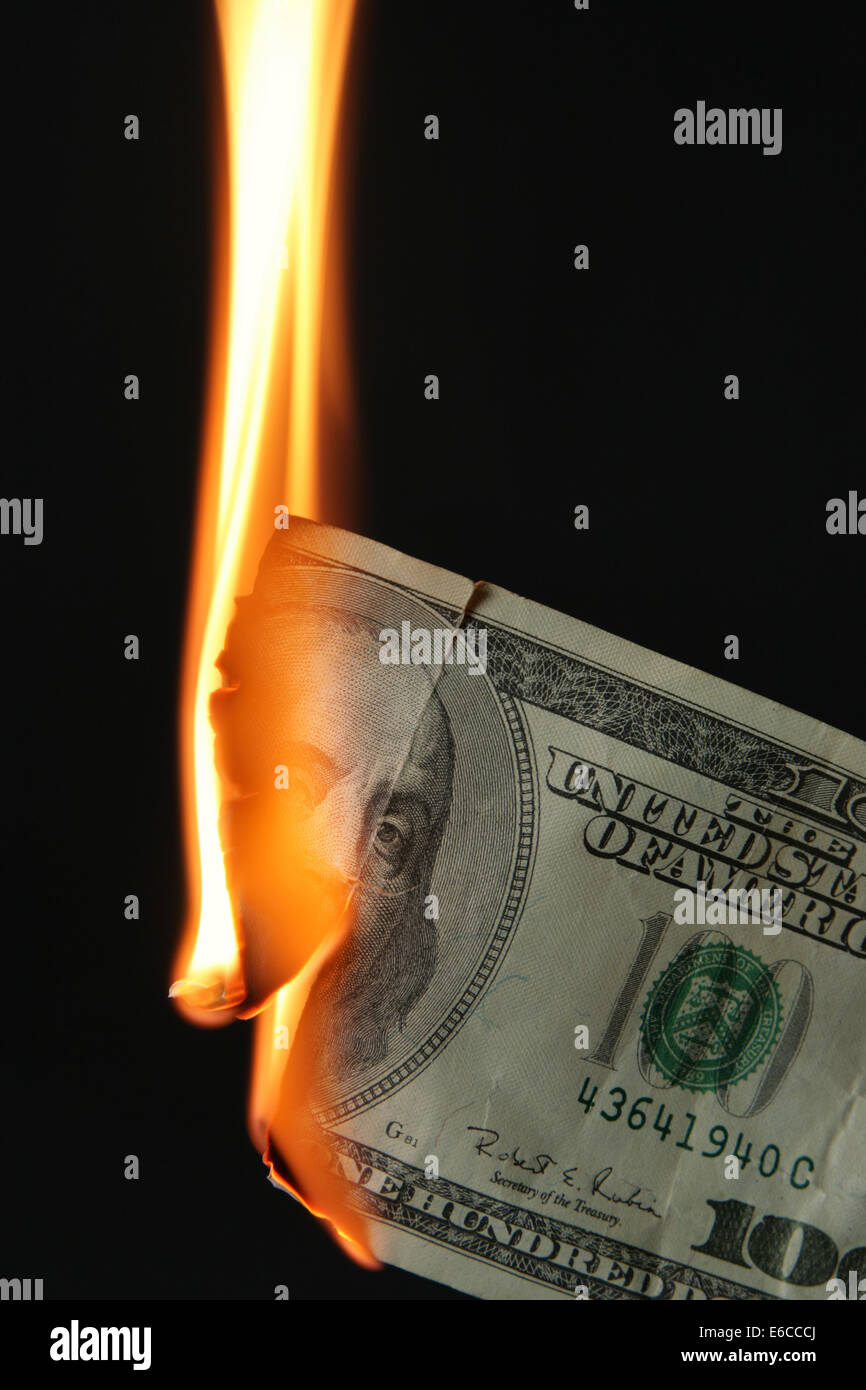 Burning dollars close up over black background Stock Photo - Alamy