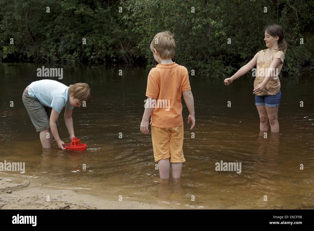 three children playing in a river Stock Photo - Alamy