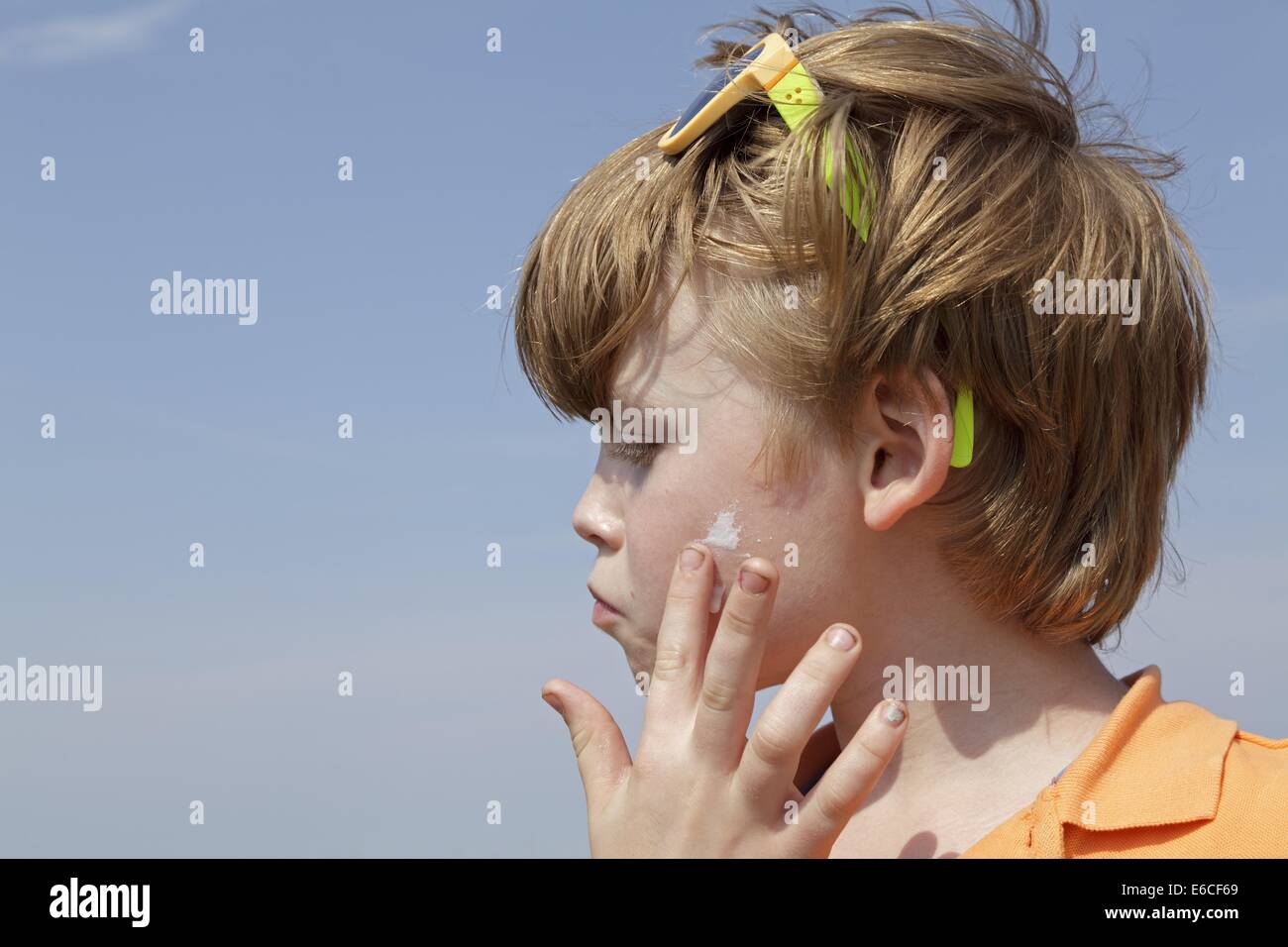 young boy applying sunscreen onto his face, Scharbeutz, Baltic Sea ...