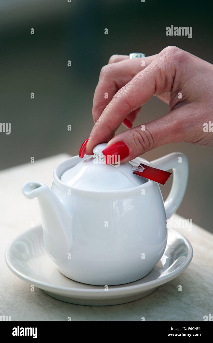 A woman opens a kettle with tea Stock Photo - Alamy