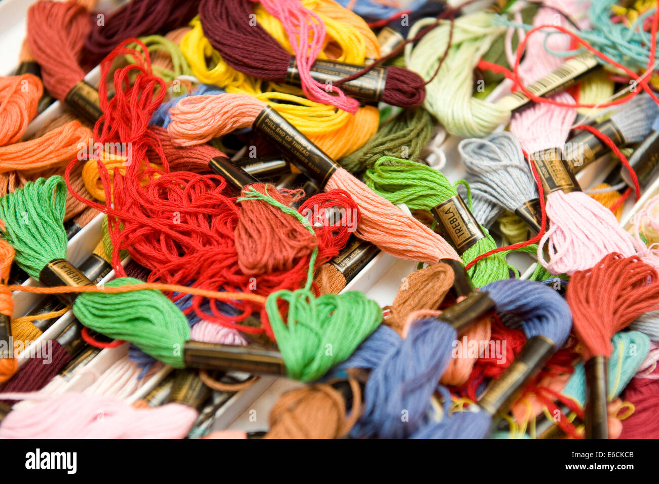 Close up on pile of brightly coloured sewing and embroidery yarns ...