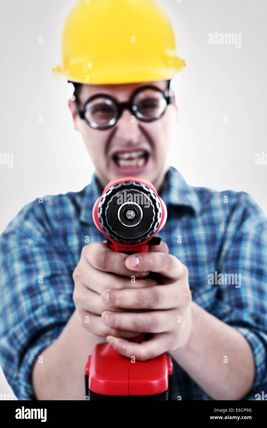 Mad Carpenter with Drill and yellow helmet Stock Photo - Alamy