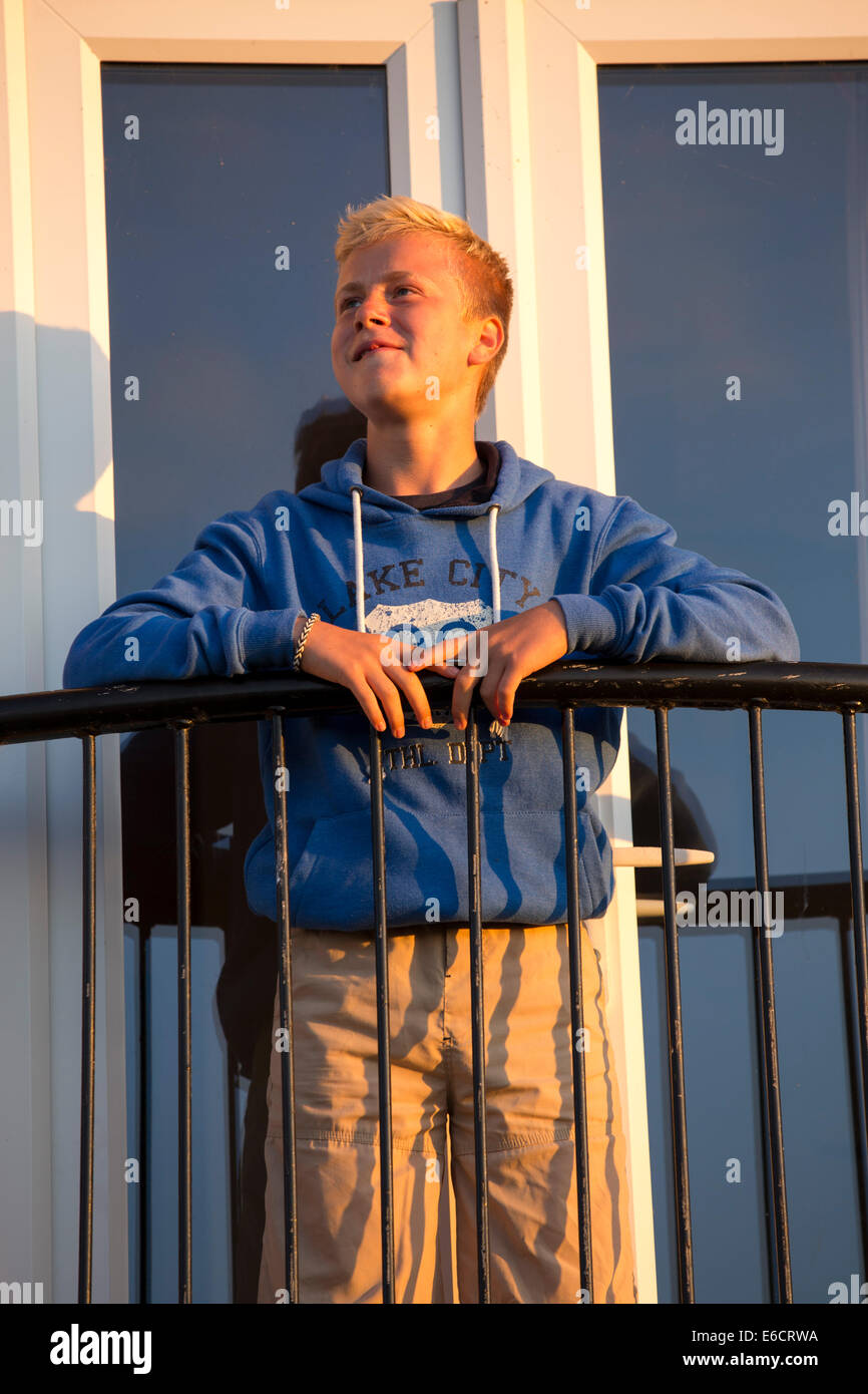 A teenage boy performing on a house balcony, Beadnell, UK Stock Photo ...