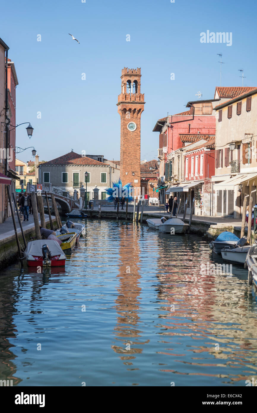 The Clock Tower is reflected in the main canal on the Island of Murano ...