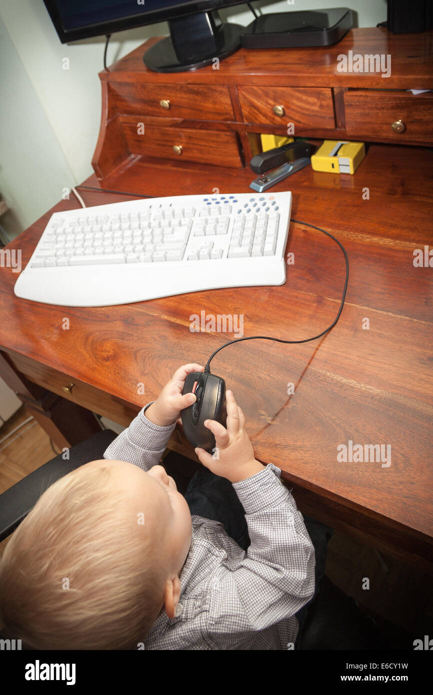 Happy childhood. Smart little boy child kid playing on the desktop ...