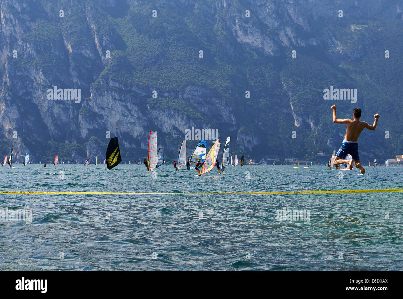 Male slackliner walking and jumping a long slackline over water, Lake ...