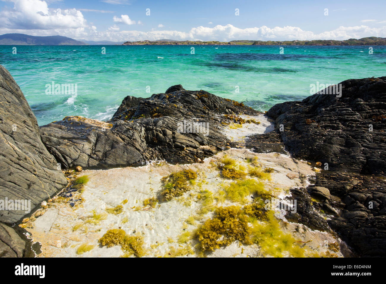 Aquamarine seas and a rock pool on the north coast of Iona, off Mull ...