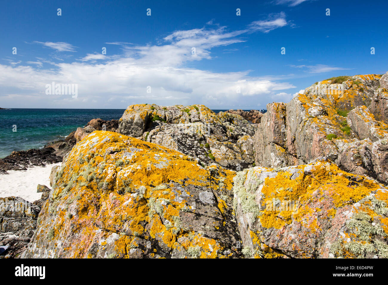 Aquamarine seas and lichen covered rock on the West coast of Iona, off ...