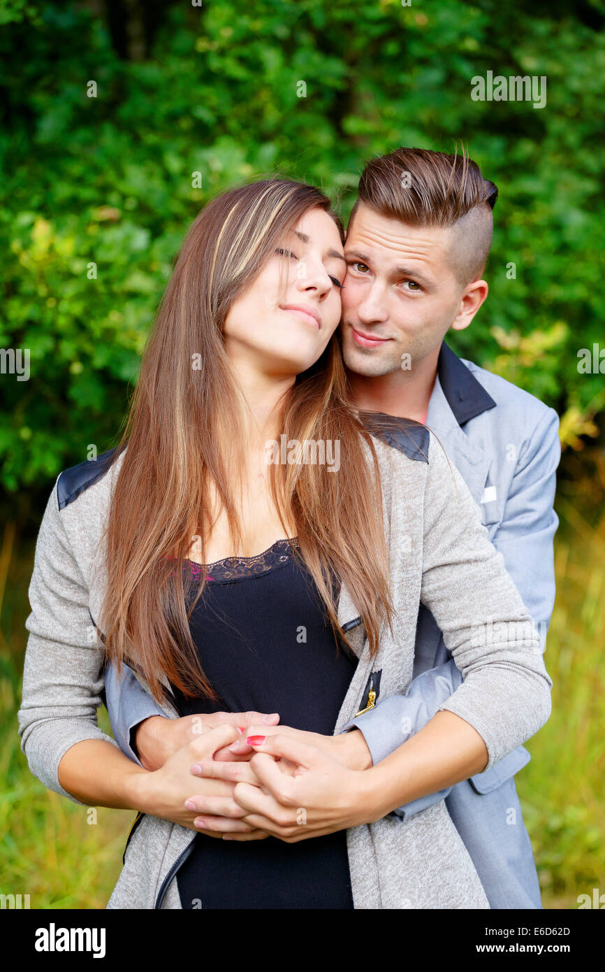 Happy smiling young couple embracing outdoor at sunny day Stock Photo ...