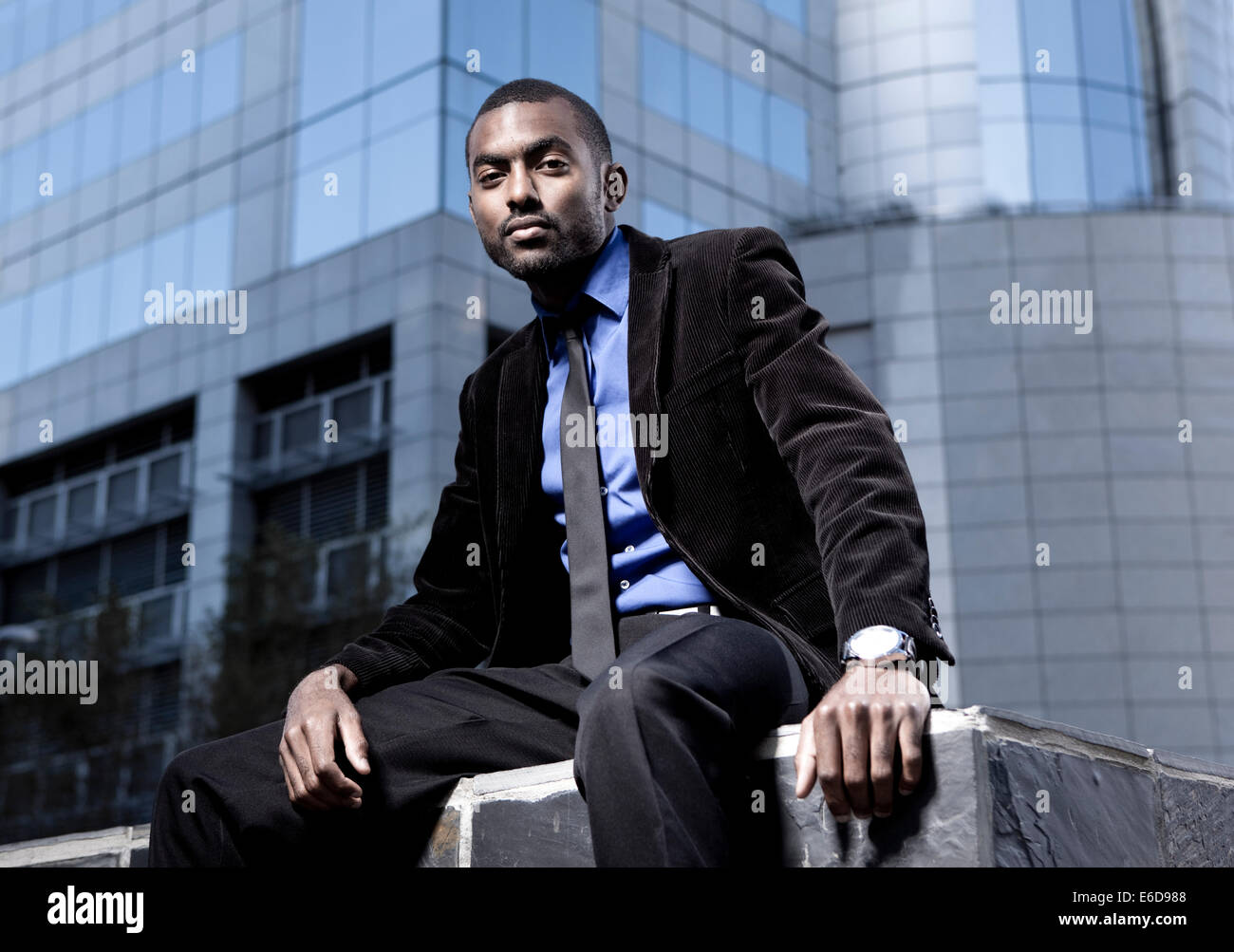Southafrica, young African business man wearing black suit sitting in ...