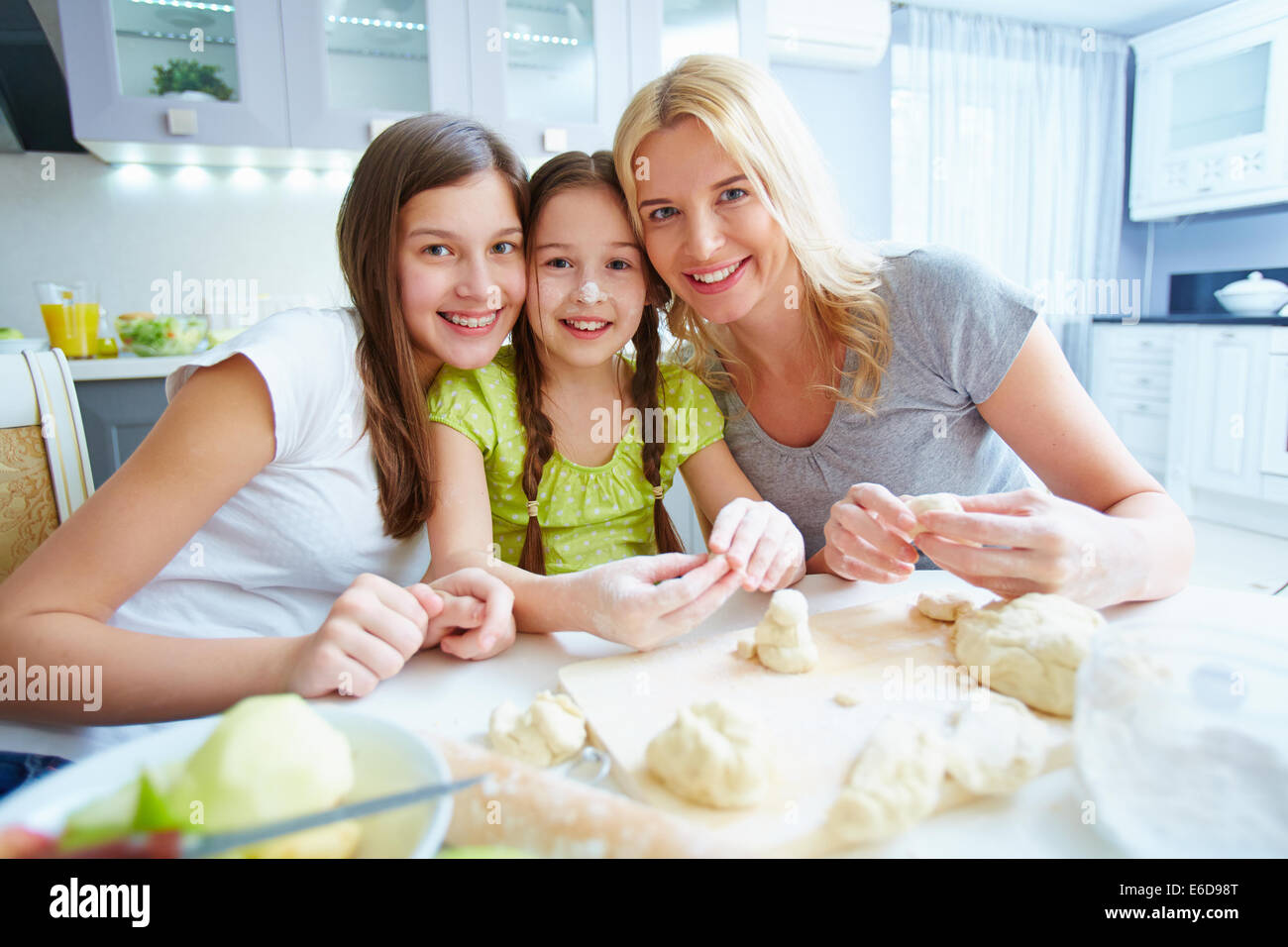 Female family smiling at kitchen table Stock Photo - Alamy