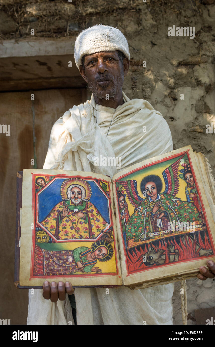 Priest holding an ancient illustrated bible outside of the church of ...