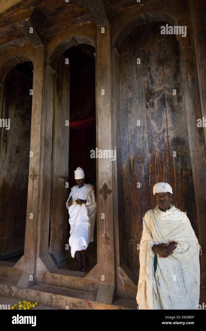 Priests by the giant wooden doors, on the exterior of the church of ...