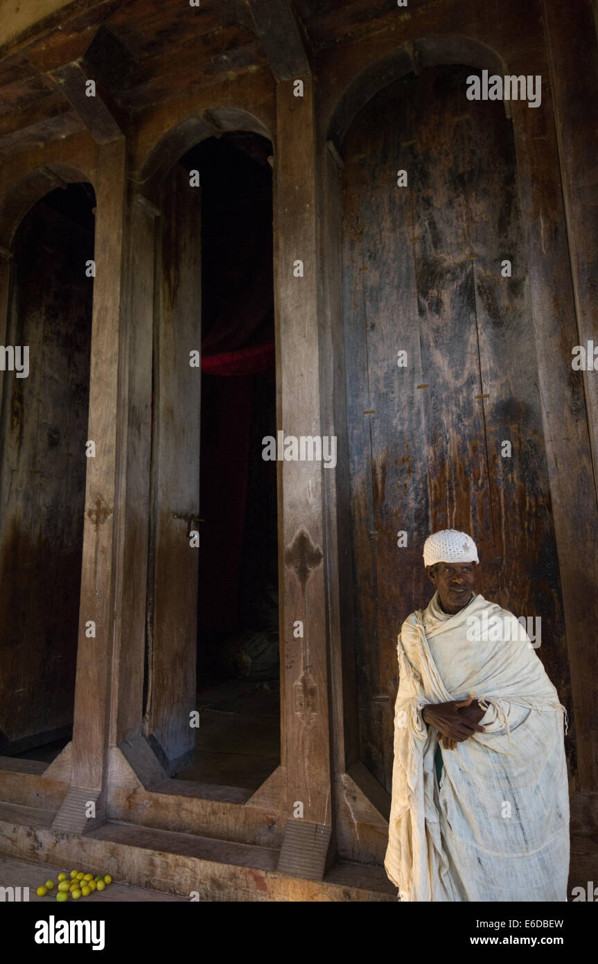 Priest leaning against a giant wooden door, on the exterior of the ...
