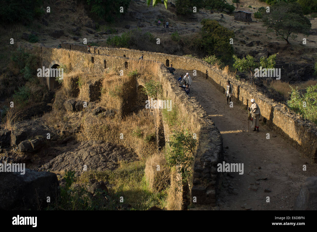 Villagers walking across the ancient stone bridge, at the Blue Nile ...
