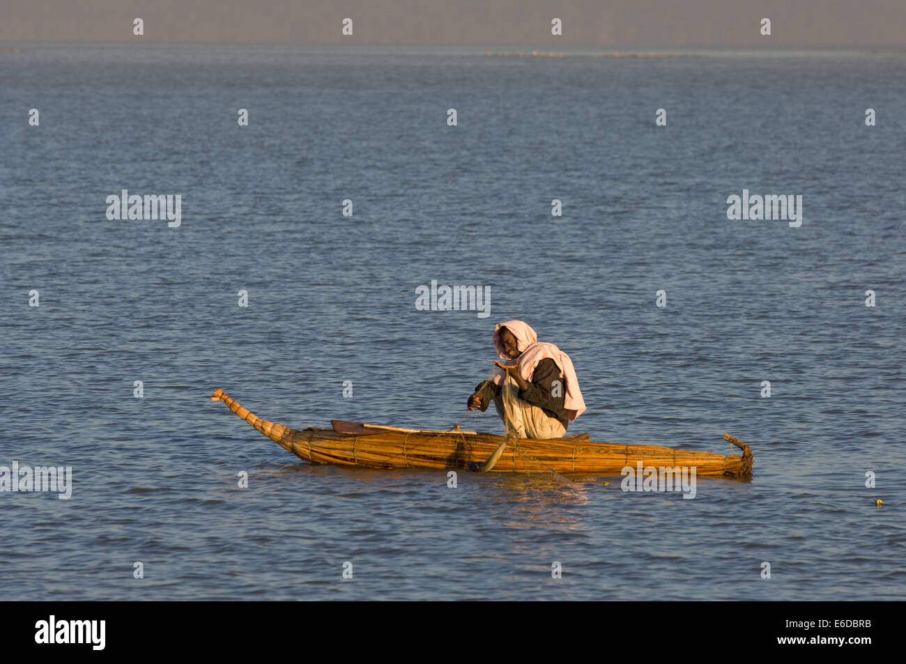 Fisherman pulling up a fishing net in a traditional tanqua papyrus boat ...