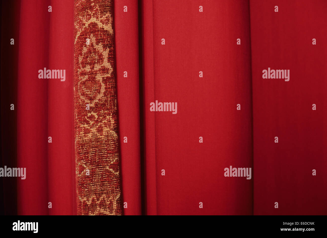 Detail of rich red curtain with folds and shadows and strip of ...