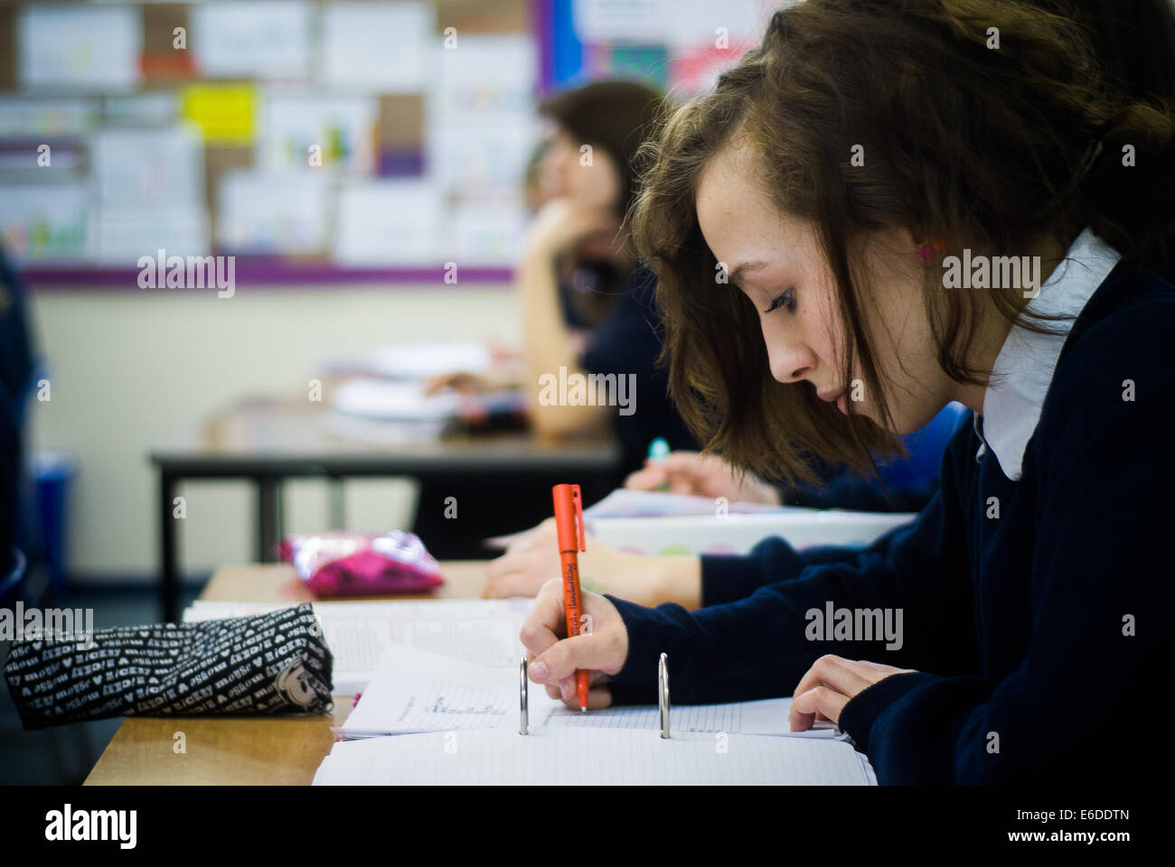 Girl pupil writing in workbook at Secondary School, Cirencester ...