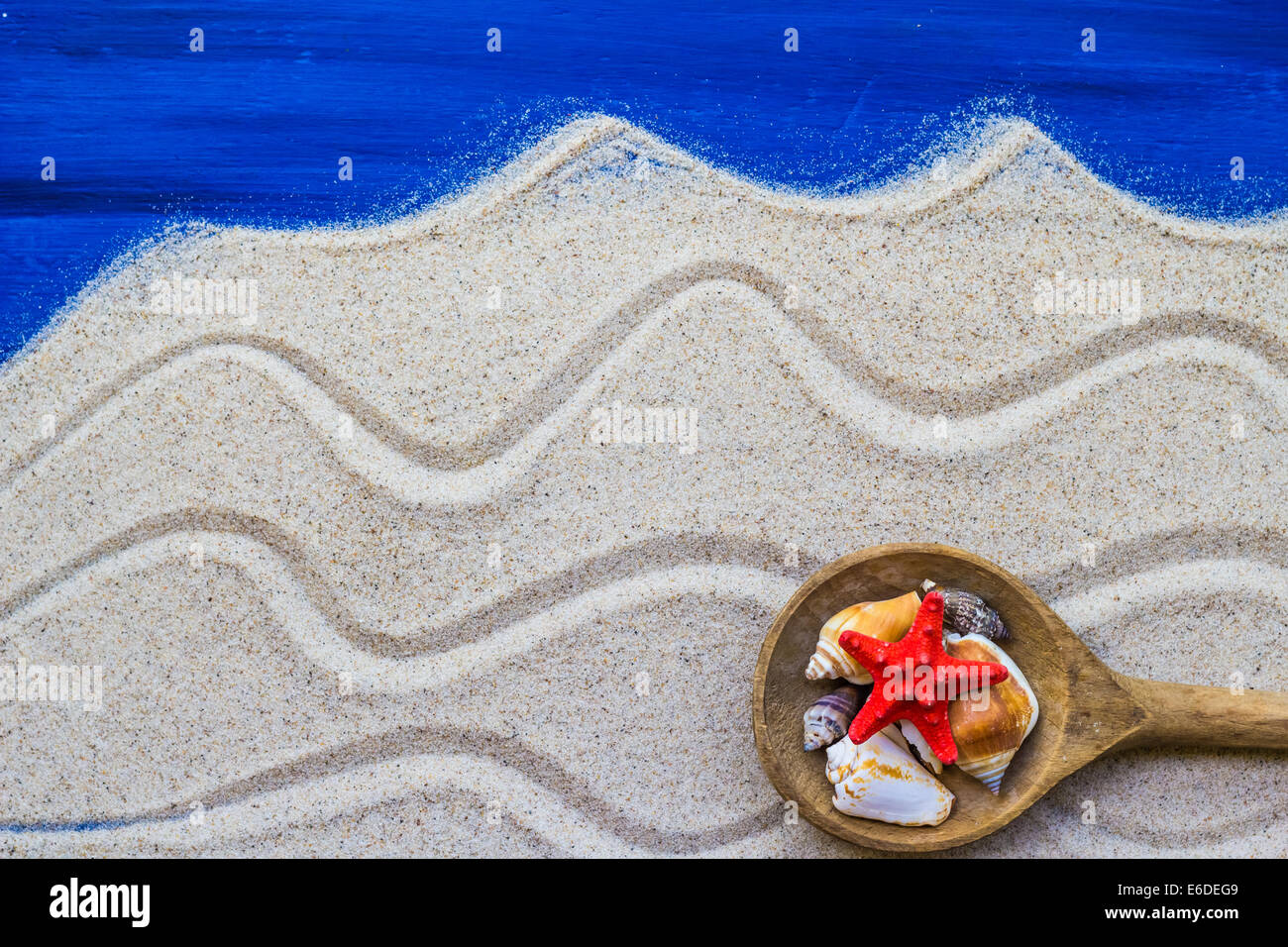 Shells colored in a spoon on the beach sand Stock Photo - Alamy