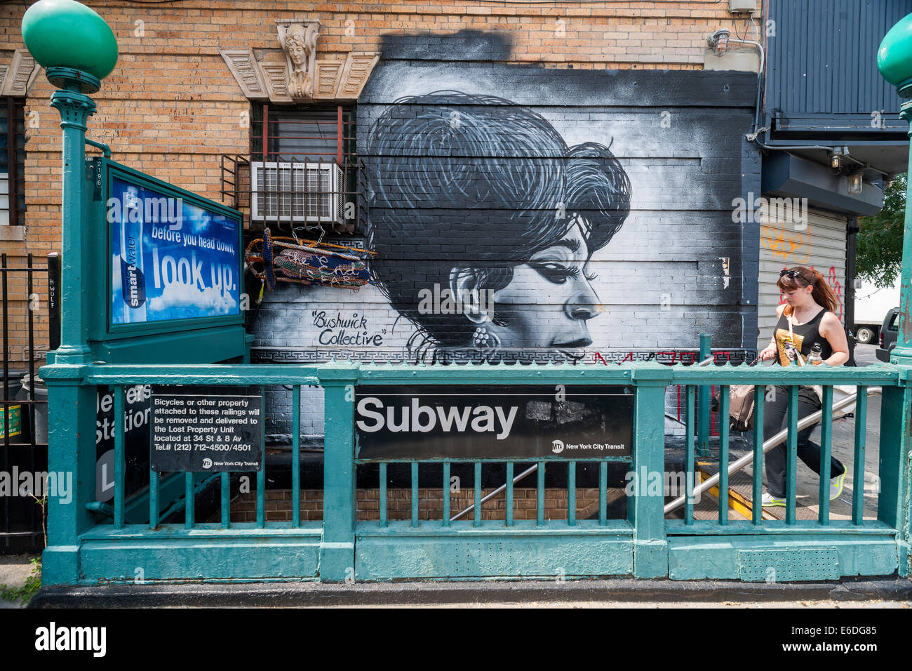 A woman enters the subway past a Bushwick Collective mural in the ...