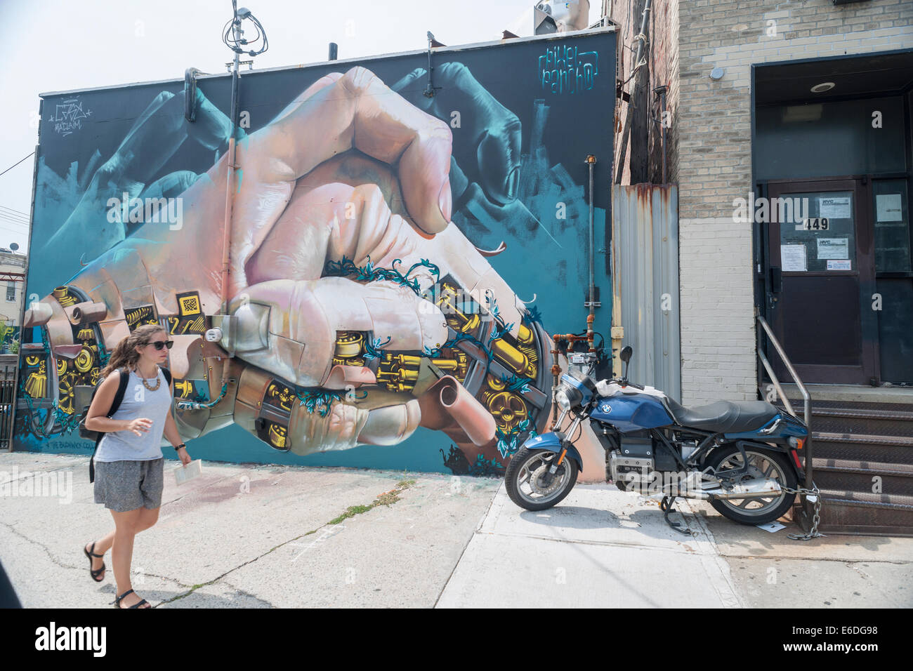 A woman passes a Bushwick Collective mural in the Bushwick neighborhood ...