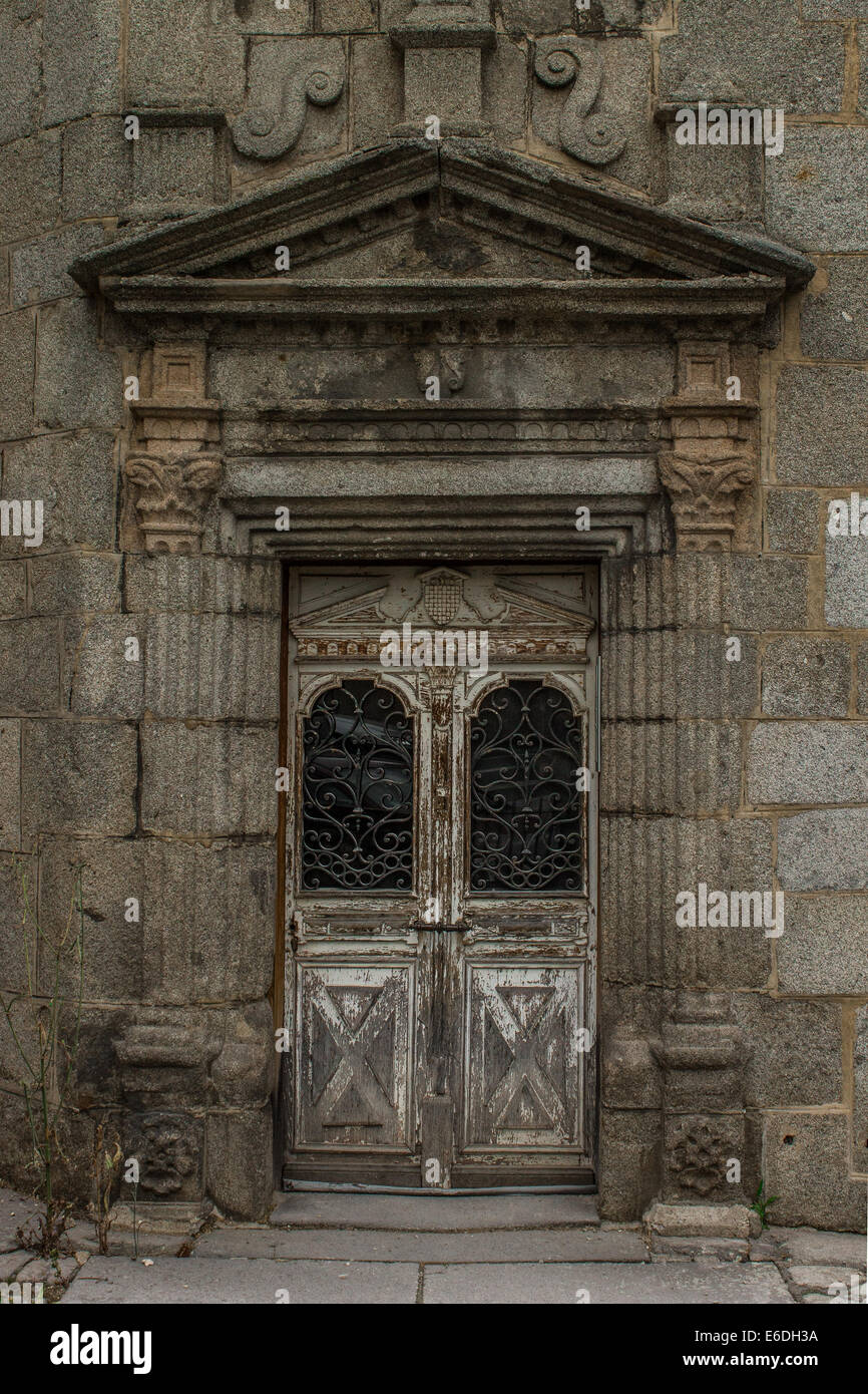 Wooden door in an old stone house with ornate stonework in central ...