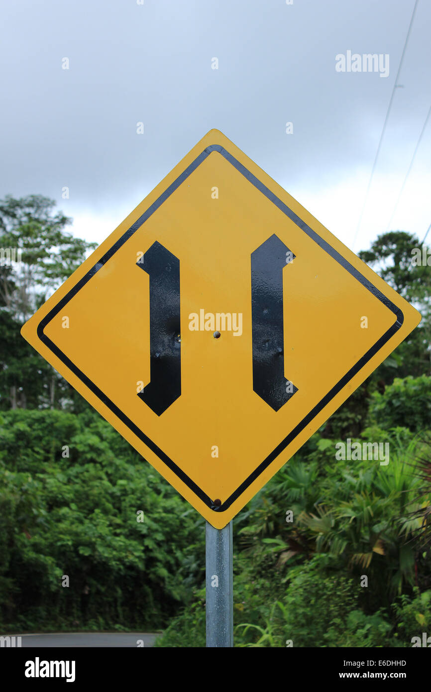 A sign indicating a narrow bridge on the Napo River in the rain forest ...