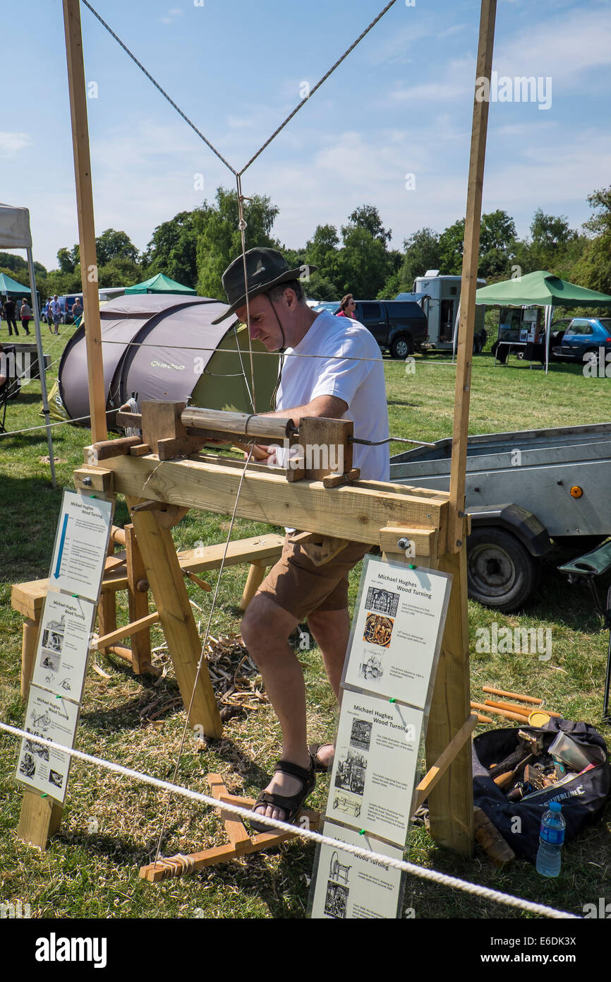 Wood turner using pole lathe to manufacture turned wood products at ...