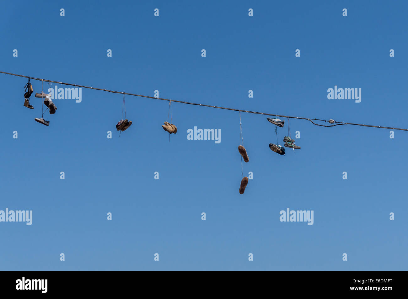 Pairs of shoes hanging from overhead wire. Shoefiti Stock Photo - Alamy